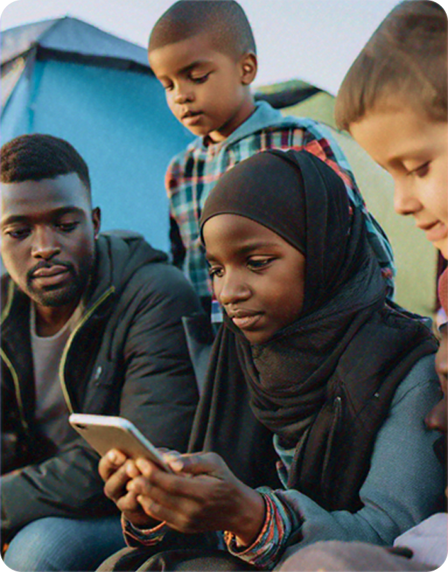 Refunite | A group of refugees gathered around a mobile device, sharing ...